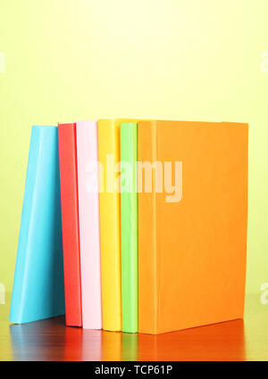 Stack of multicolor books on green background Stock Photo - Alamy