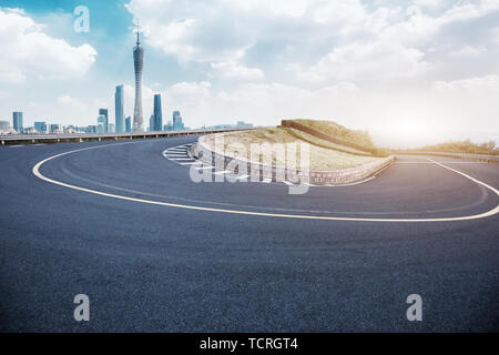 empty asphalt sharp turn with modern city Stock Photo - Alamy