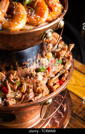 Charcoal fire frog pot field chicken meal Stock Photo - Alamy