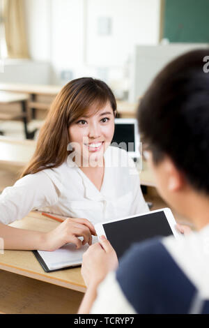 Two asian student discuss content on tablet when study in classroom ...