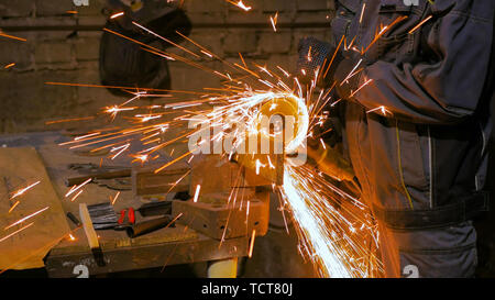 Blacksmith sawing metal with hand circular saw Stock Photo - Alamy