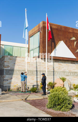 Flag raising outside municipal offices in Paracas, Peru, South America ...