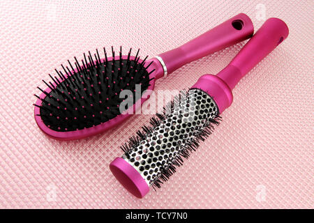 Comb brushes on pink background Stock Photo - Alamy