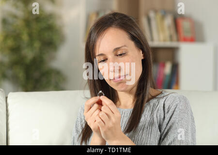 Serious woman with engagement ring looks away in a park Stock Photo - Alamy