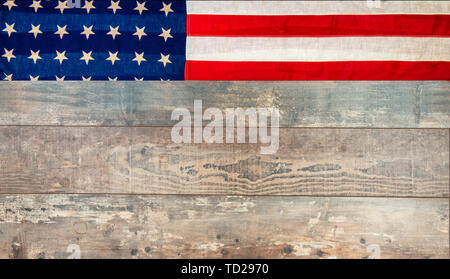 an American flag lying on an aged, weathered rustic wooden background ...