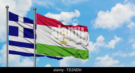 Tajikistan and Greece flag waving in the wind against white cloudy blue ...