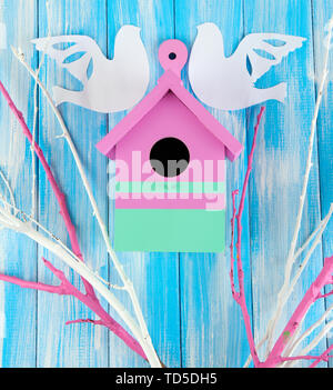 Decorative nesting box with paper birds and color branches, on color ...