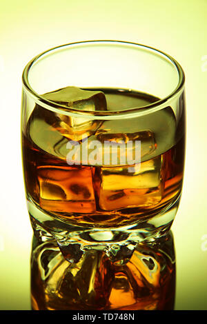 Brandy glass with ice on green background Stock Photo - Alamy