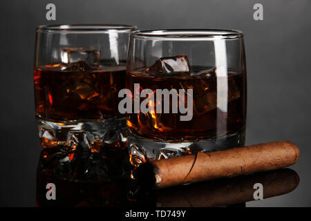 Brandy glasses with ice on grey background Stock Photo - Alamy