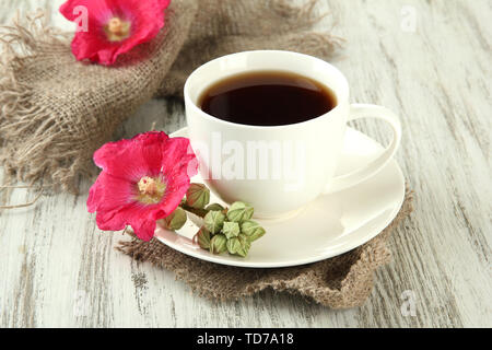 Cup of coffee and pink mallow flowers on wooden background Stock Photo ...