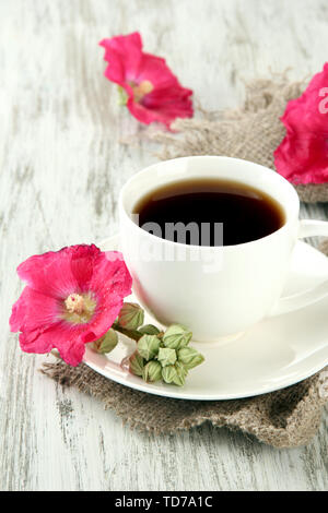 Cup of coffee and pink mallow flowers on wooden background Stock Photo ...