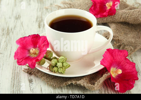 Cup of coffee and pink mallow flowers on wooden background Stock Photo ...