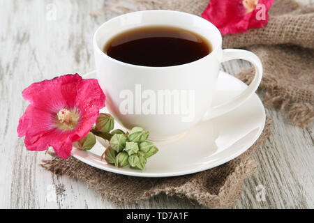 Cup of coffee and pink mallow flowers on wooden background Stock Photo ...