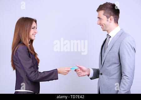 Successful business people changing business cards on grey background ...