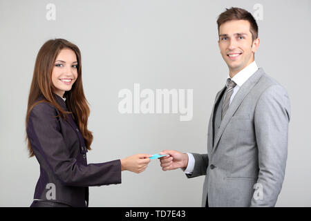 Successful business people changing business cards on grey background ...