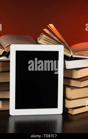 Tablet and books on bright background Stock Photo - Alamy