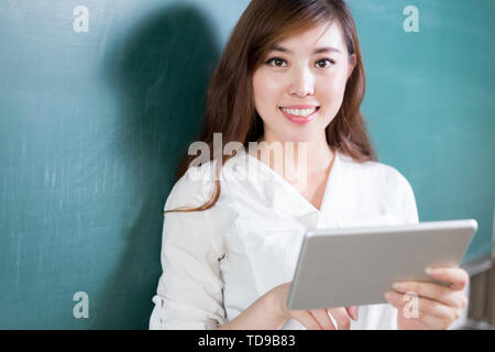 Asian beautiful female student holding book in library Stock Photo - Alamy