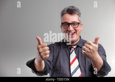 Happy gleeful man giving a double thumbs up Stock Photo - Alamy