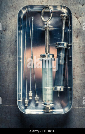 Syringes and needle in a stainless steel container. Unsterile syringes ...