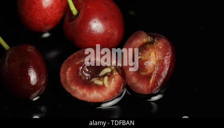 Fruit worms in rotten cherry, black background. Larva of cherry flies ...