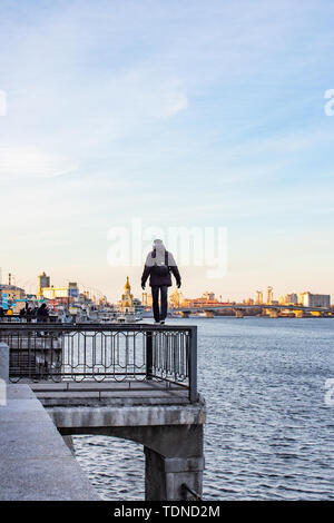 A man walks along the railing of a bridge before diving in the Limmat ...