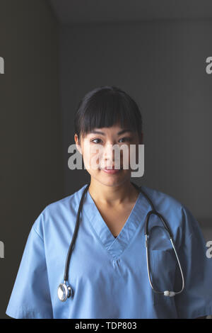 young Asian woman doctor standing with arms crossed in white lab coat ...