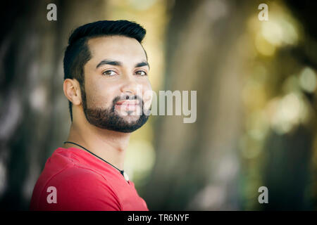 Young smiling german guy in headphones using translator app on mobile ...
