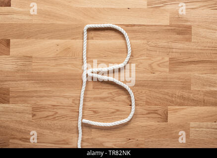 The letter E formed with white rope on a wooden table Stock Photo - Alamy