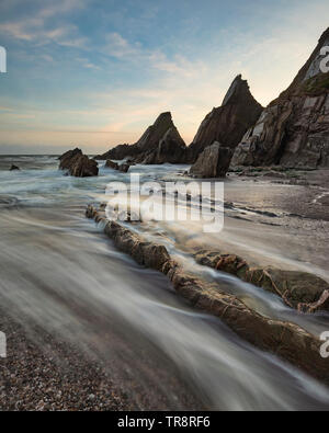 Beautiful sunset landscape image of Westcombe Beach in Devon England ...