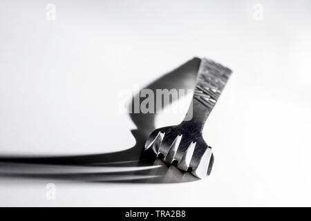 Dinner Fork throws large Shadow on white background. Concept of Shadow ...