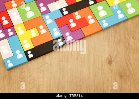 image of tangram puzzle blocks with people icons over wooden table ...