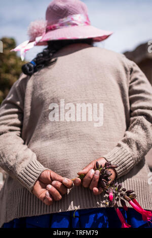 Local woman walking with a buch of flowers on Taquile Island, Lake ...