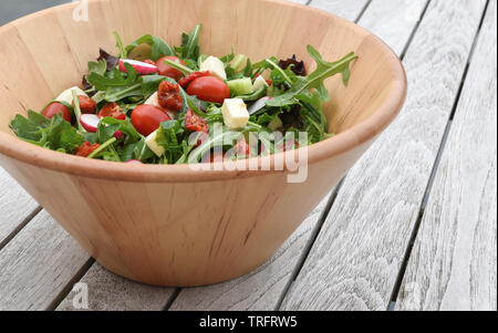 Green lettuce Salad with mozzarella cheese arugula and tomato on wooden ...