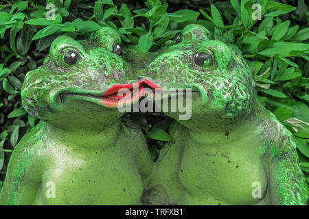 Two kissing frogs decor sculpture in garden backyard. Love story ...