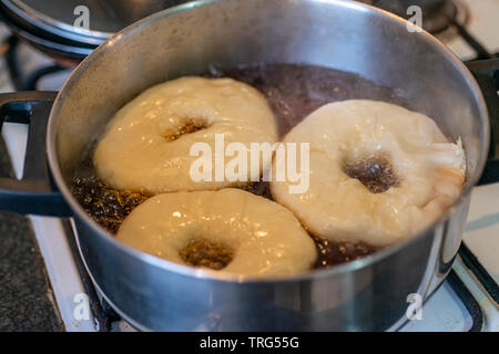 Boiling american bagel before being baked Stock Photo - Alamy
