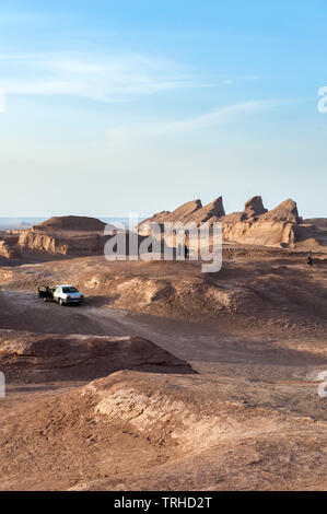 Tourists watch the sunset over yardangs, called kuluts in Iran, in the ...