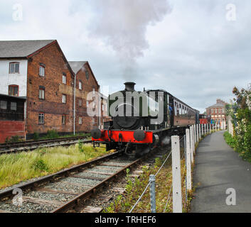 A steam locomotive pulling out of Oswestry Station alongside the signal ...