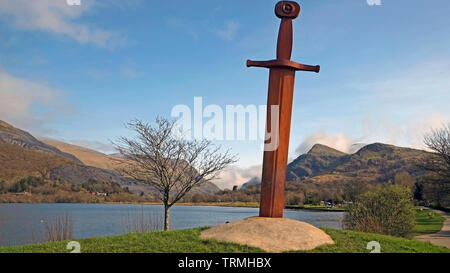 King Arthur's sword in the stone before a replica neolithic thatched ...