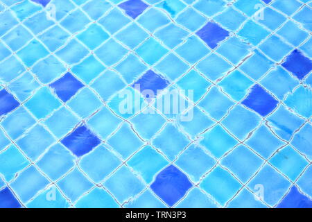 swimming pool ceramic tiles covered in clear water. light blue tiles ...