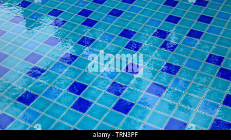 swimming pool ceramic tiles covered in clear water. light blue tiles ...