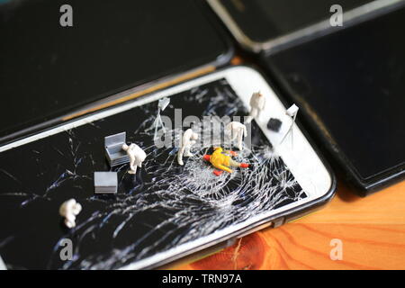the accident of tiny man falling down on the screen of mobile Stock ...