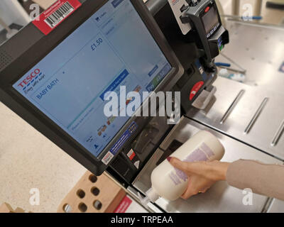 Paying for goods at the self service can check out in a Tesco ...