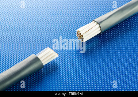 Cross-section of control cable on blue ribbed technological background ...