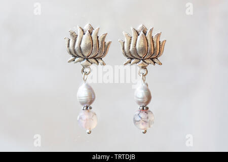 pearl beads lotus shape earrings on neutral background Stock Photo - Alamy