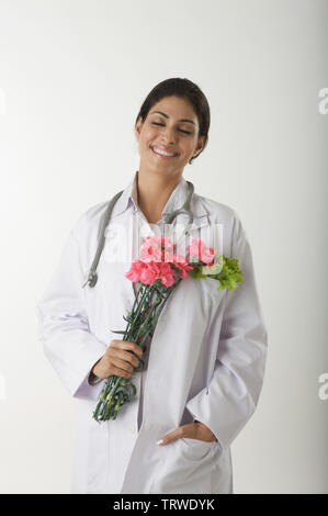 Female doctor holding bunch of flowers and smiling Stock Photo - Alamy