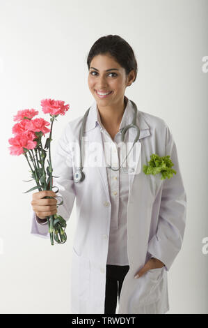 Female doctor holding bunch of flowers and smiling Stock Photo - Alamy