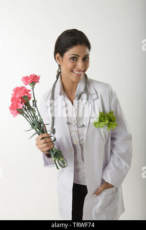 Female doctor holding bunch of flowers and smiling Stock Photo - Alamy
