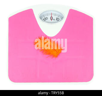 Feather on scales. Heavy feather weight ton Stock Photo - Alamy