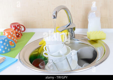 Stack of dishes soaking in kitchen sink Stock Photo - Alamy