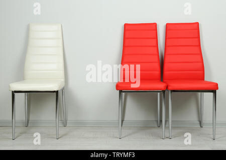 Modern color chairs on wall background Stock Photo - Alamy